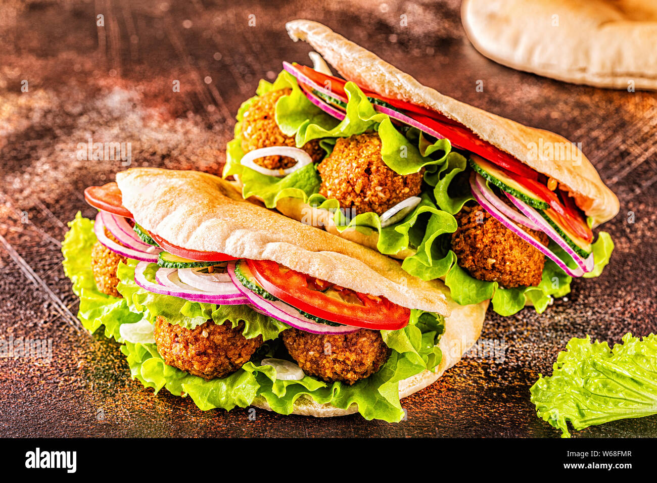 Falafel and fresh vegetables in pita bread on dark background Stock ...
