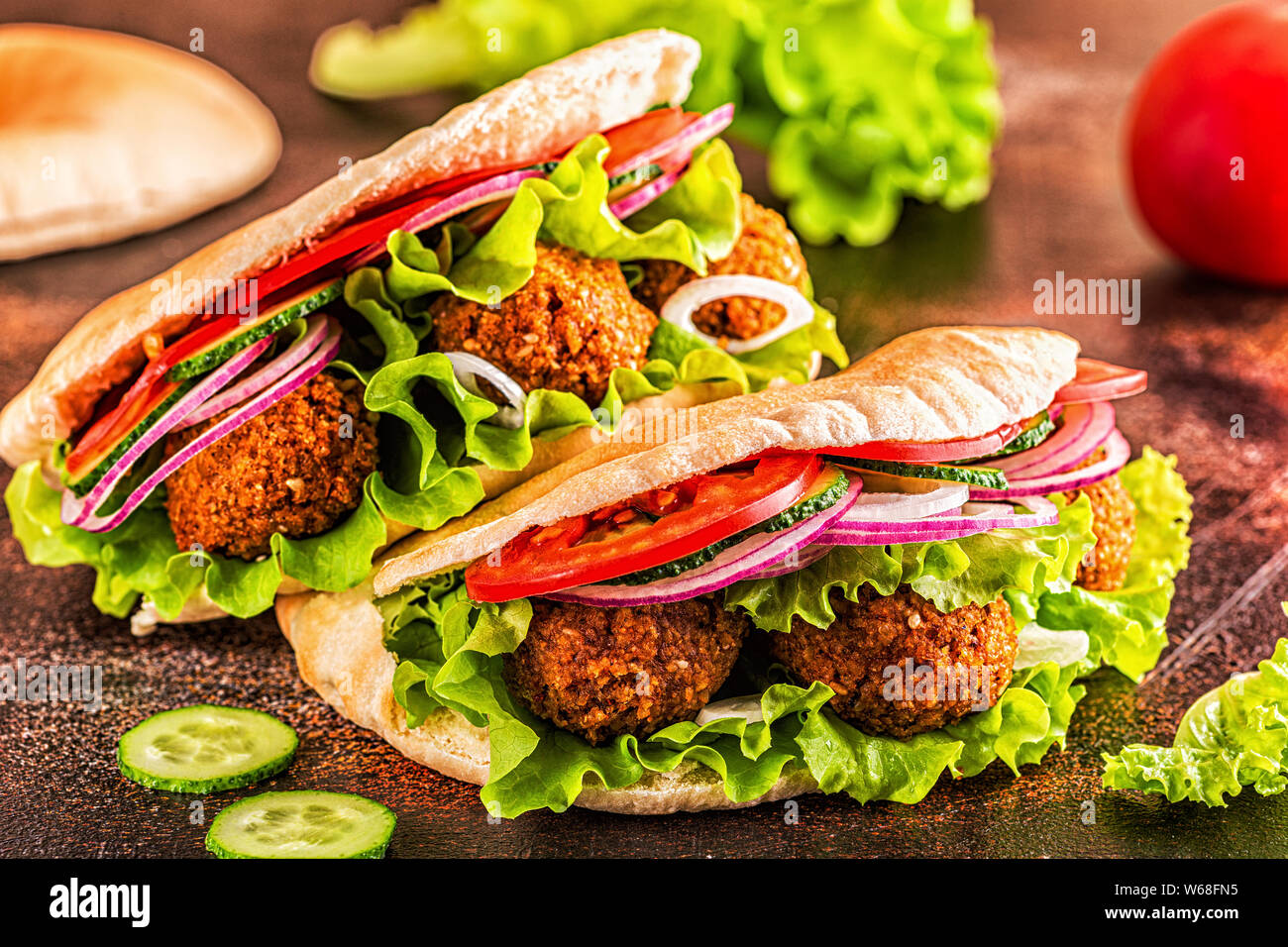 Falafel and fresh vegetables in pita bread on dark background Stock ...