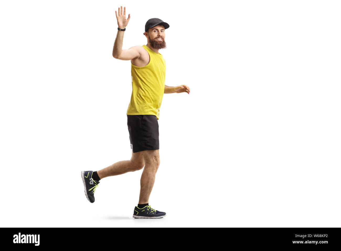 Full length shot of a bearded man jogging and waving isolated on white ...
