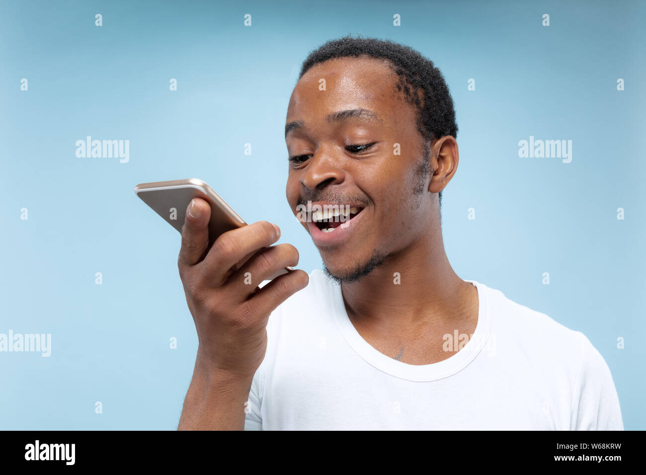 Half-length portrait of young african-american man in white shirt on ...