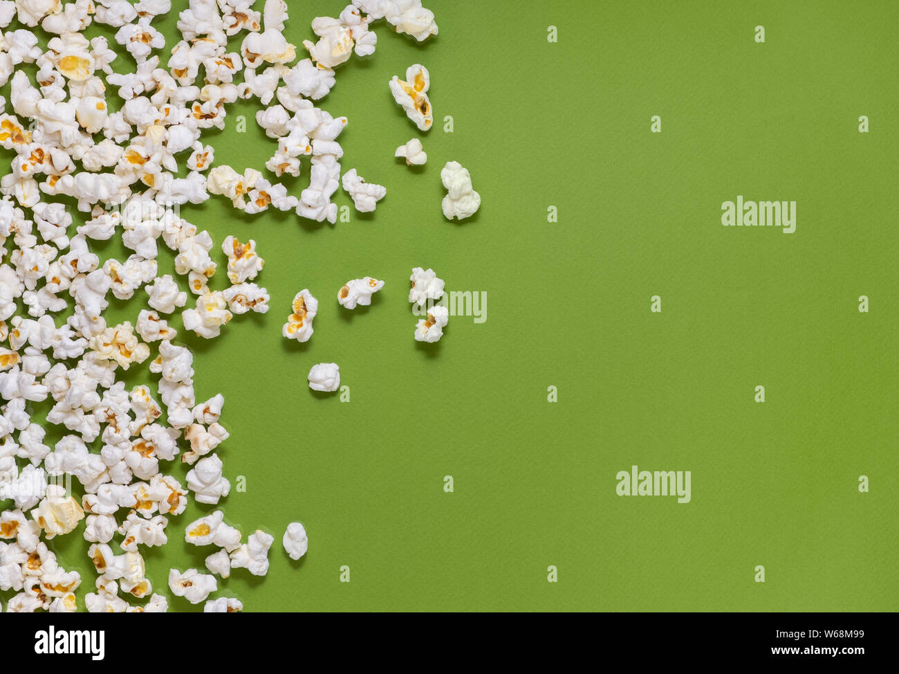 White tasty popcorn on a green background. Popcorn pattern on green ...