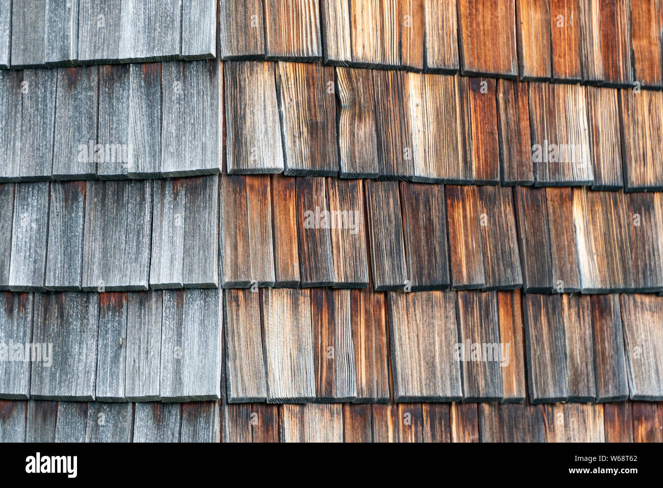 Weathered and faded from the sun wooden shingles that are the facade of ...
