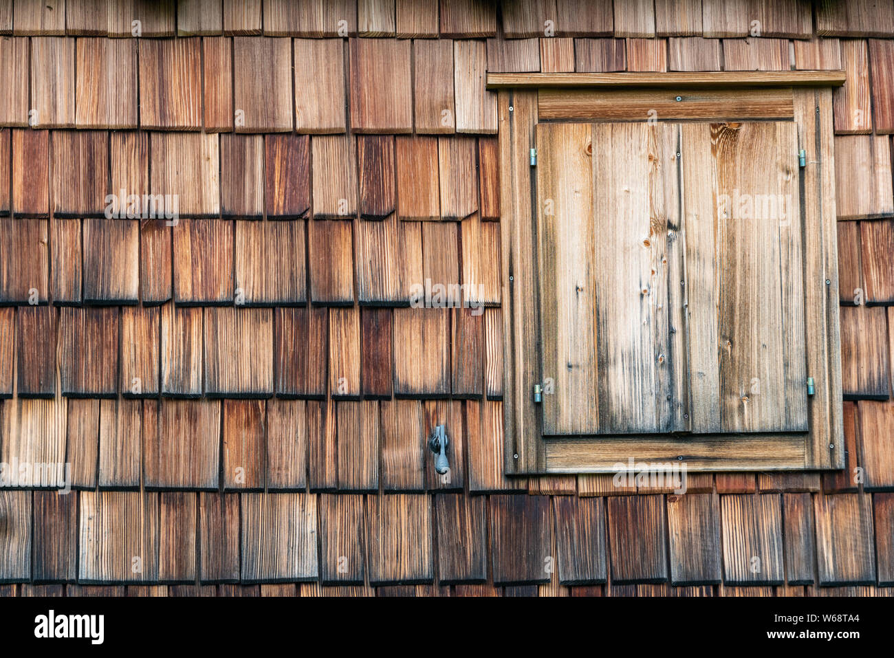 Weathered and faded from the sun wooden shingles that are the facade of ...
