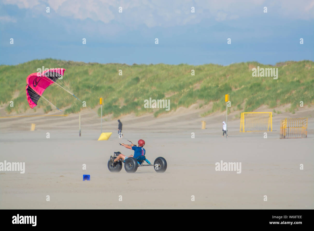 Off-road driving wind buggy on sandy beach with green sandy dunes ...