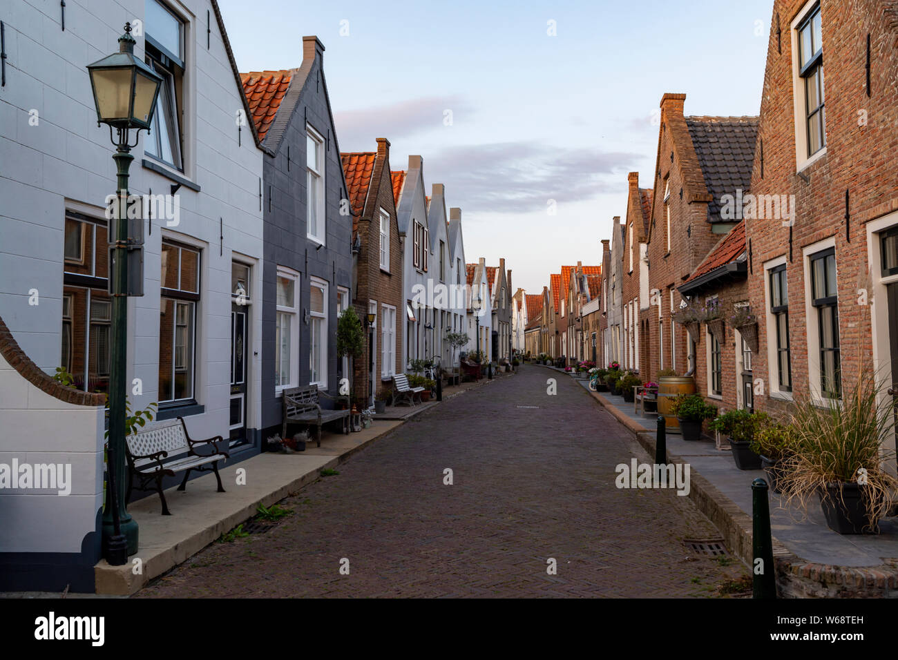 Street view with old houses in small Dutch town Goedereede on sunset ...
