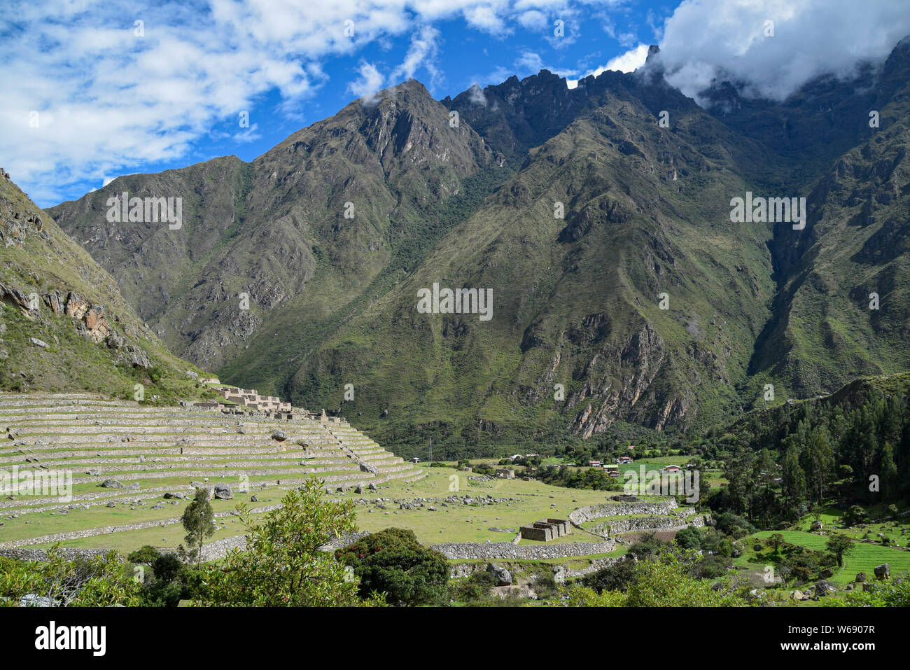 Old inca ruins in the valley, surrounded by mountains and green farm ...