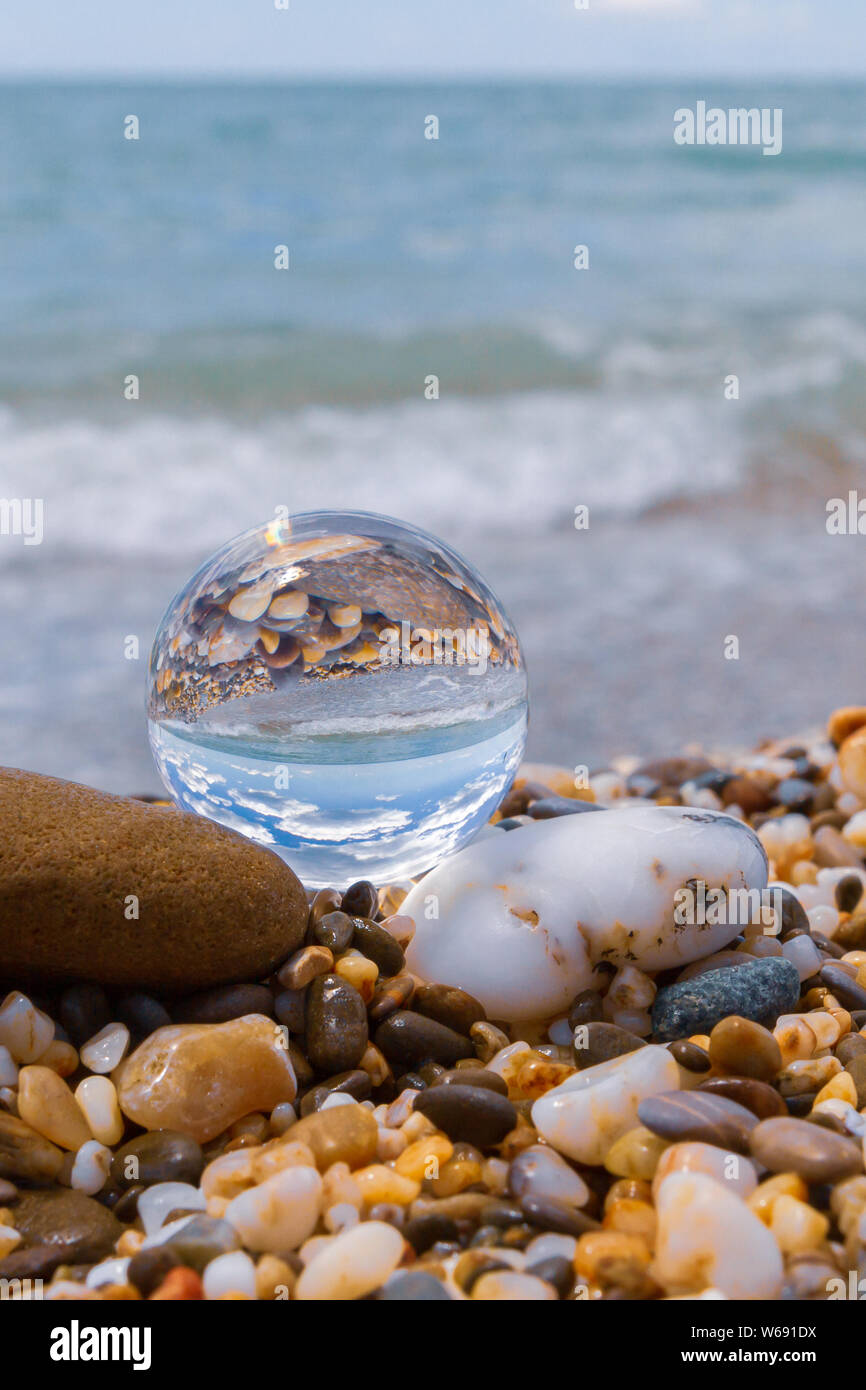 Glass round ball on the beach reflects the sea in summer Stock Photo ...