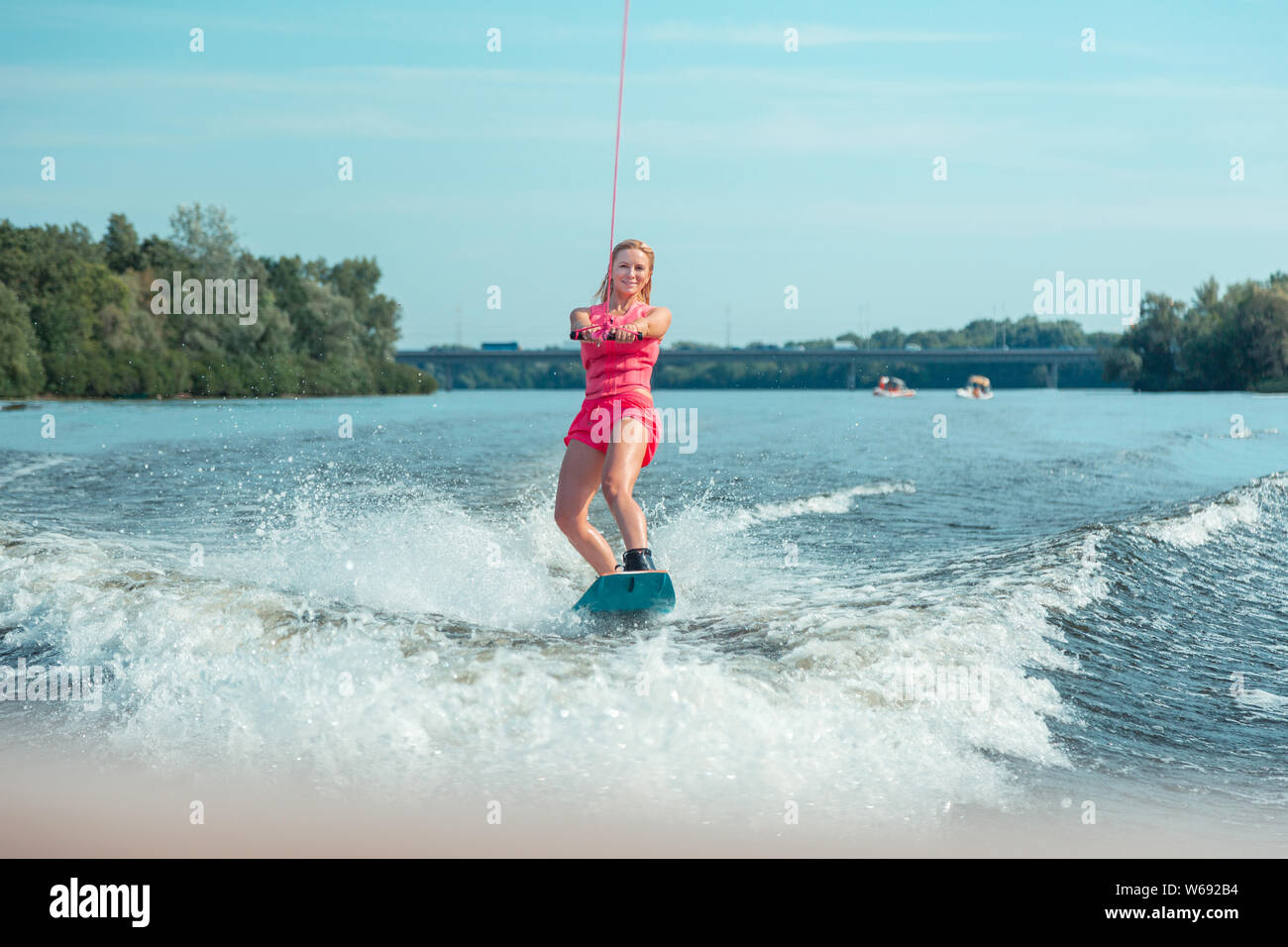 Smiling sporty fit blonde girl riding a wakeboard Stock Photo - Alamy