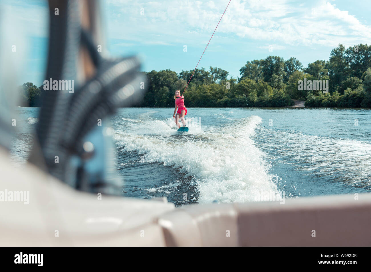 Confident fit professional female wakeboarder riding a wakeboard Stock ...
