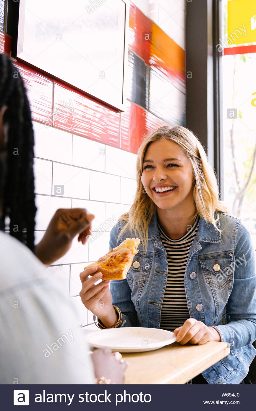 Woman sitting and eating pizza hi-res stock photography and images - Alamy