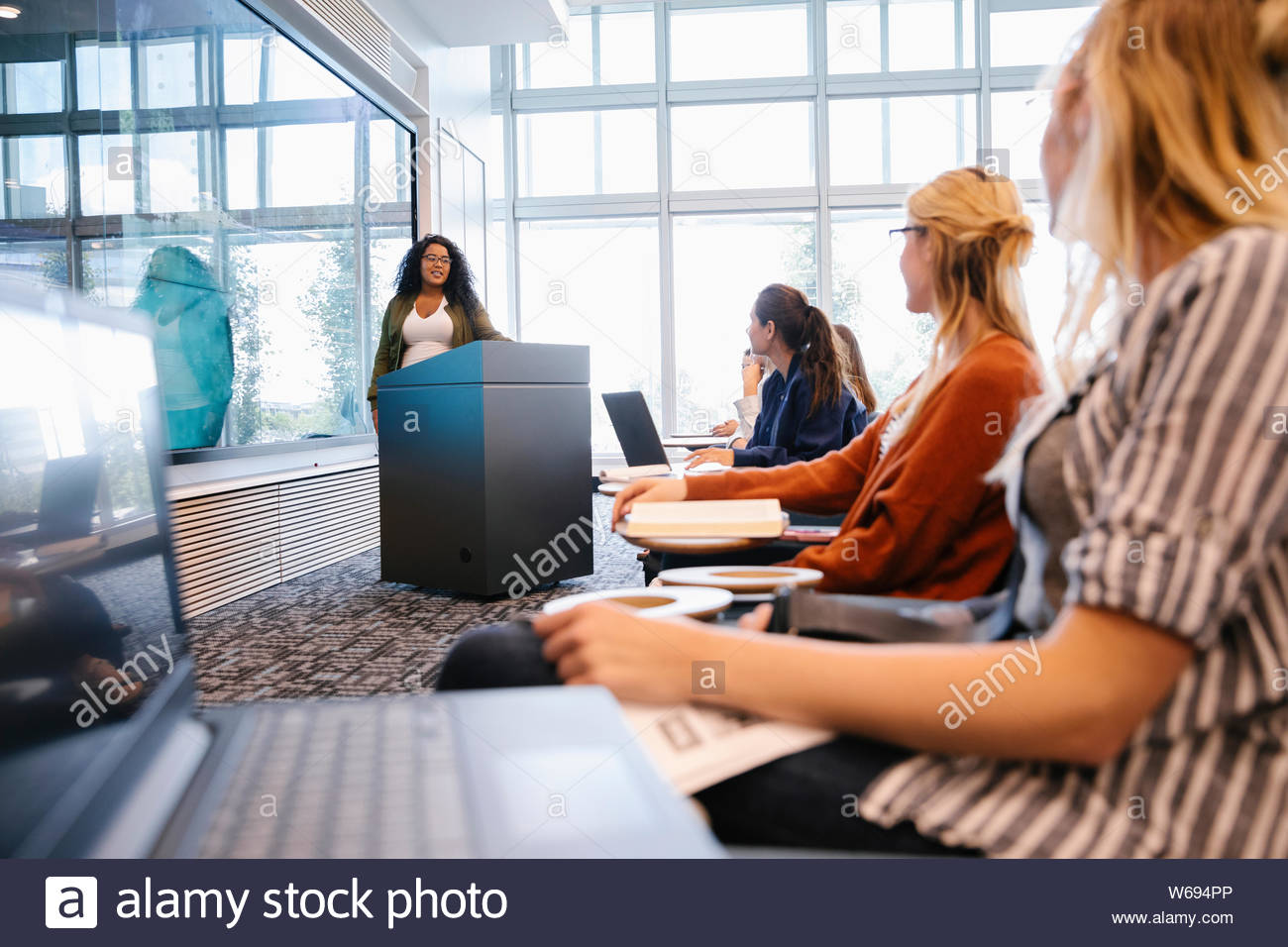 Student giving presentation from podium in seminar Stock Photo - Alamy