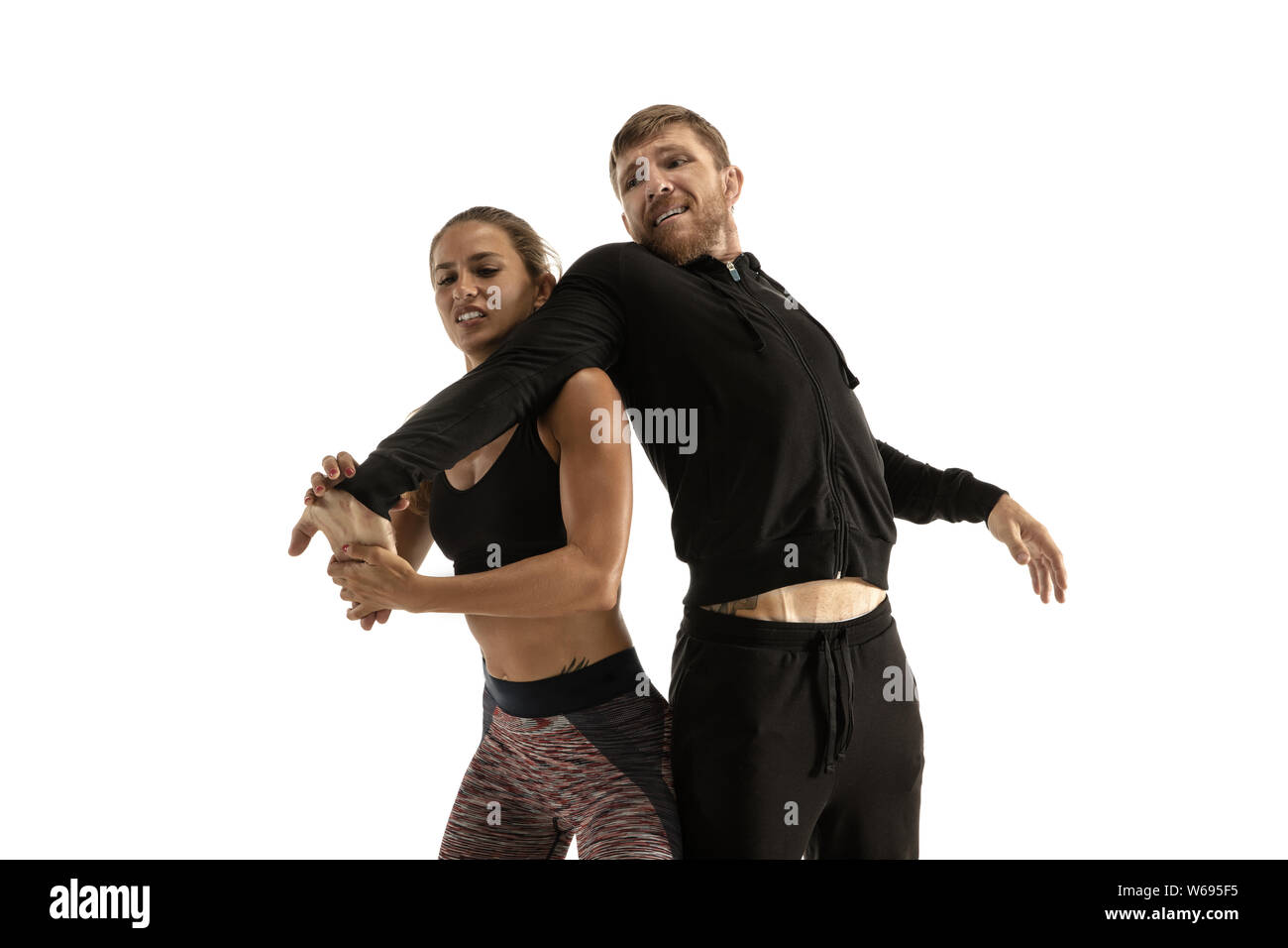 Man in black outfit and athletic caucasian woman fighting on white ...