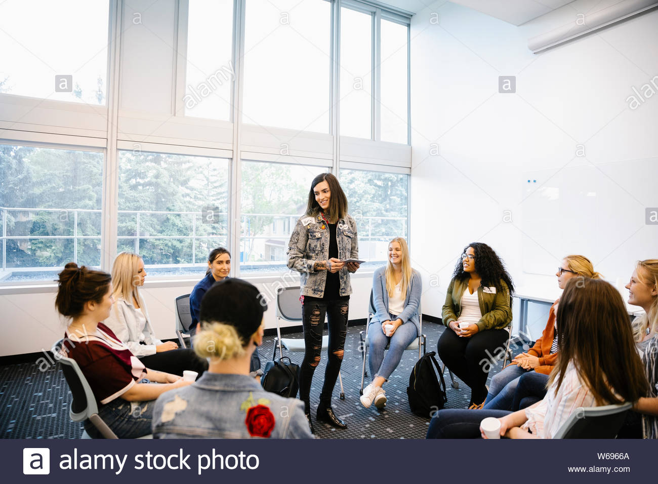 Student standing in seminar with tablet and talking Stock Photo - Alamy