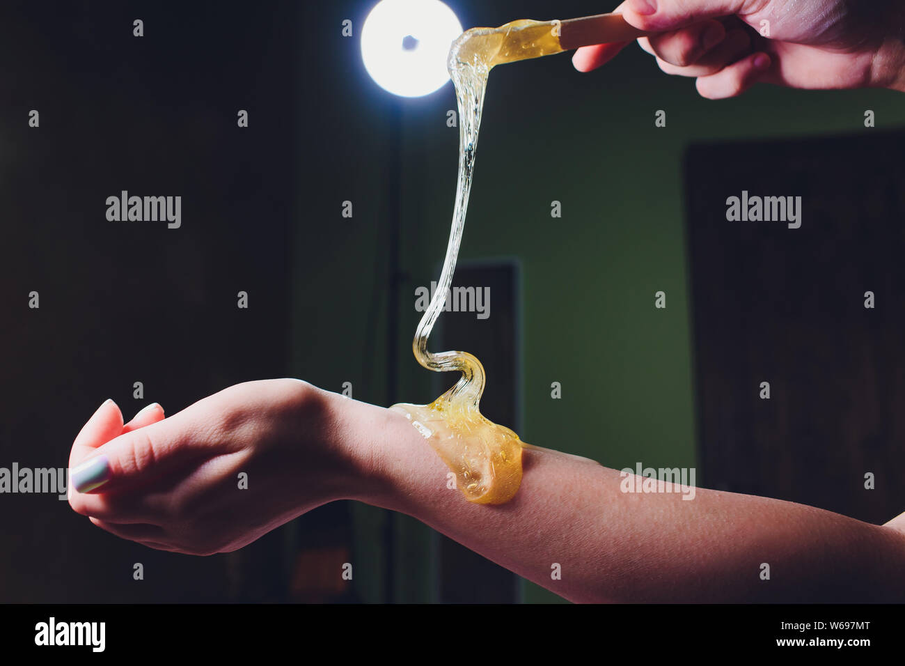 Sugaring. Beauty Concept. Young beautiful girl with dark hair gets the ...