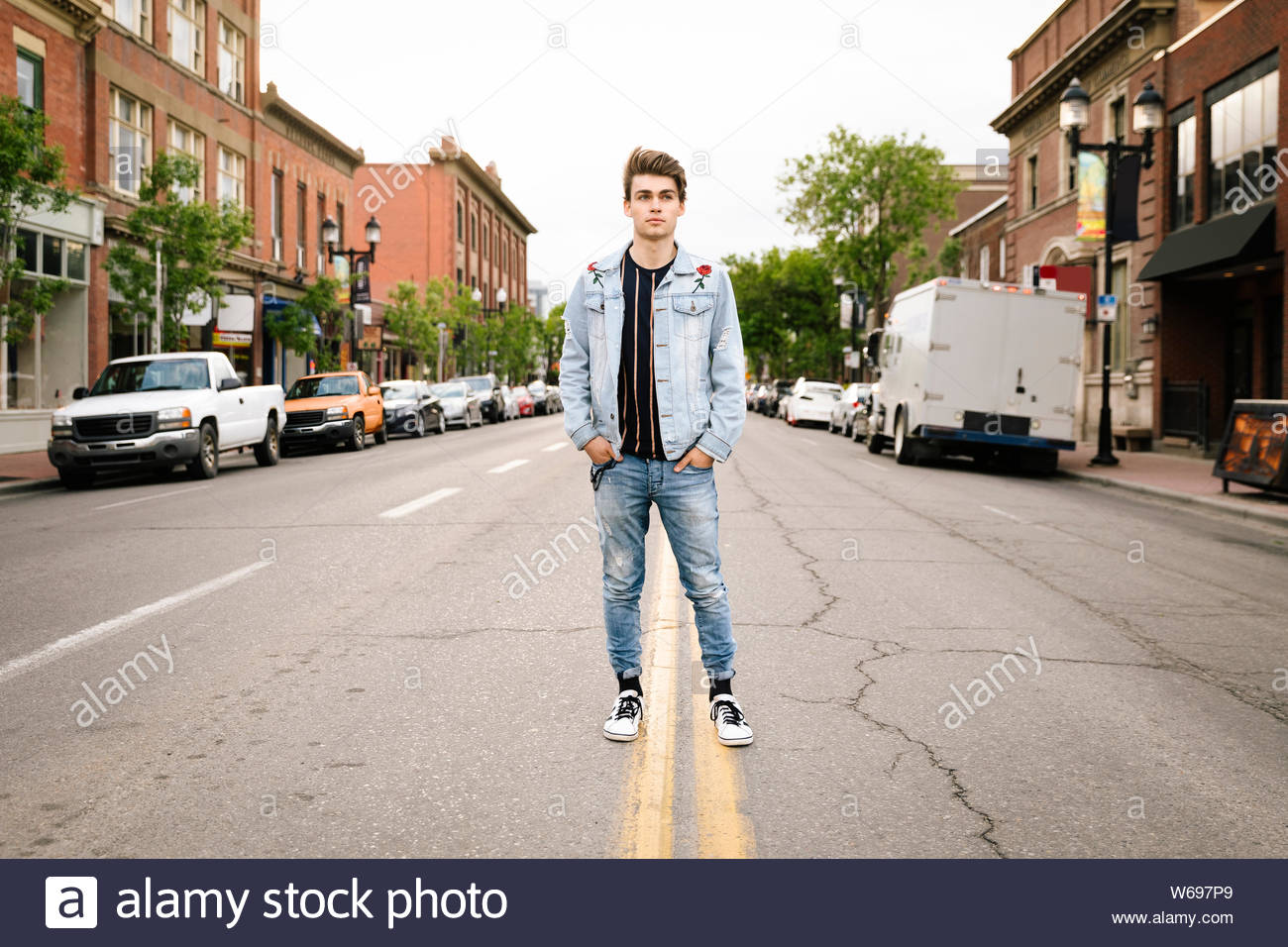 Portrait confident young man standing in middle of street Stock Photo ...