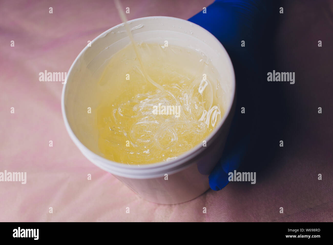 wax for sugaring in a cosmetic jar in the hands of a master in a beauty ...