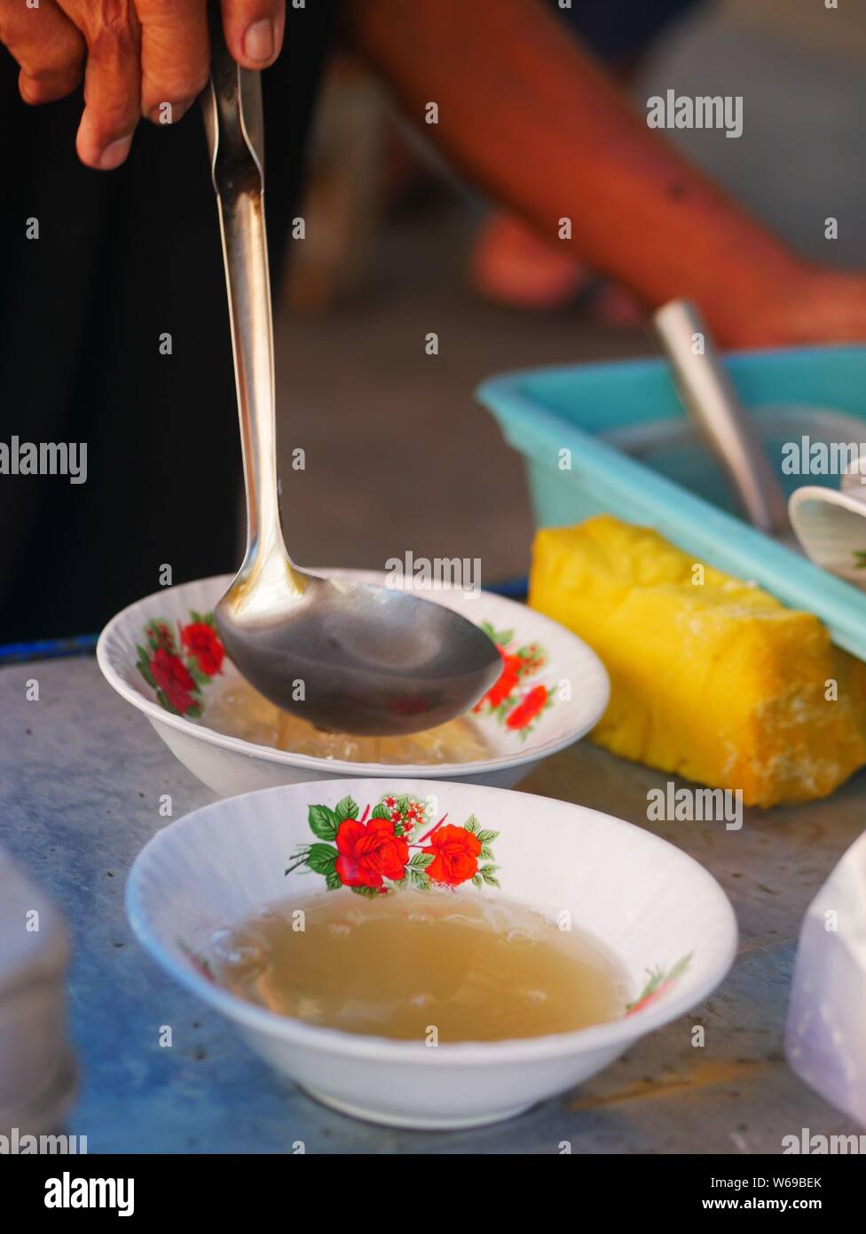 Seller prepared tahok for customer. Tahok is a pudding-like dish with a ...