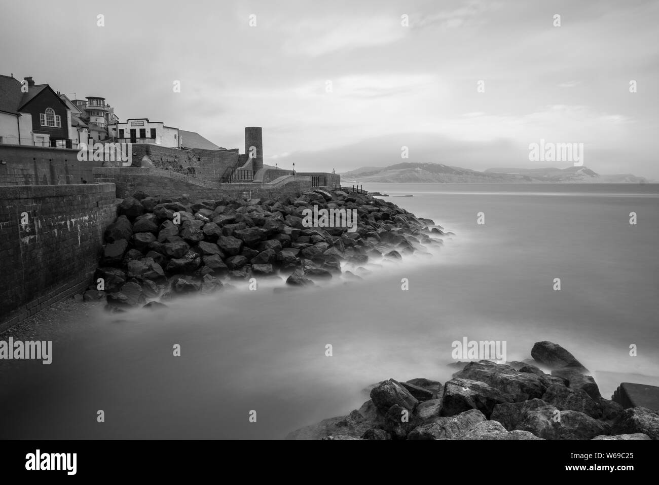 Long exposure of the sea washing up against the rocks at Lyme Regis in ...