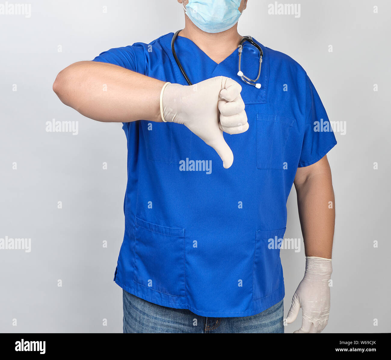 doctor in blue uniform and white latex sterile gloves shows a gesture ...