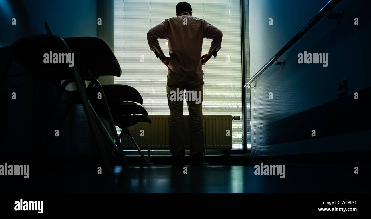 Lonely patient in full length in modern hospital waiting lobby room ...