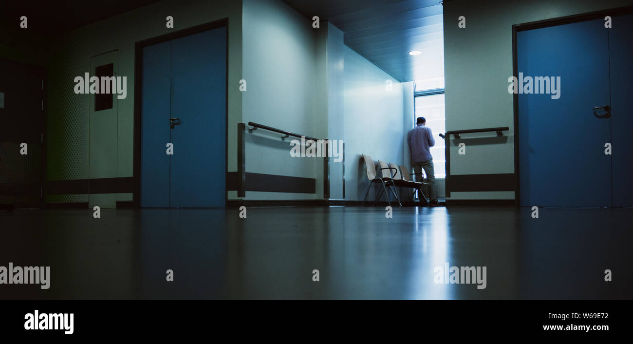 Lonely patient in full length in modern hospital waiting lobby room ...