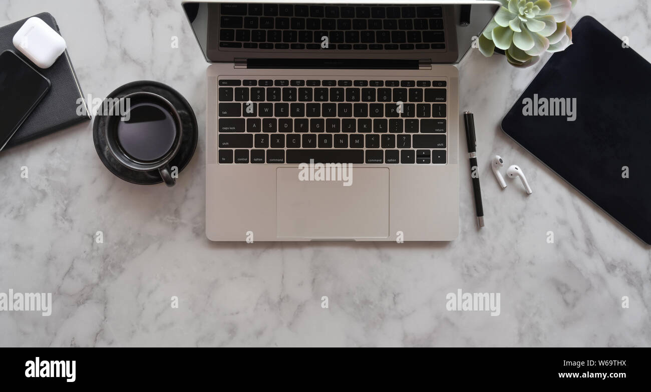 Open laptop with office supplies and decorations on marble desk ...