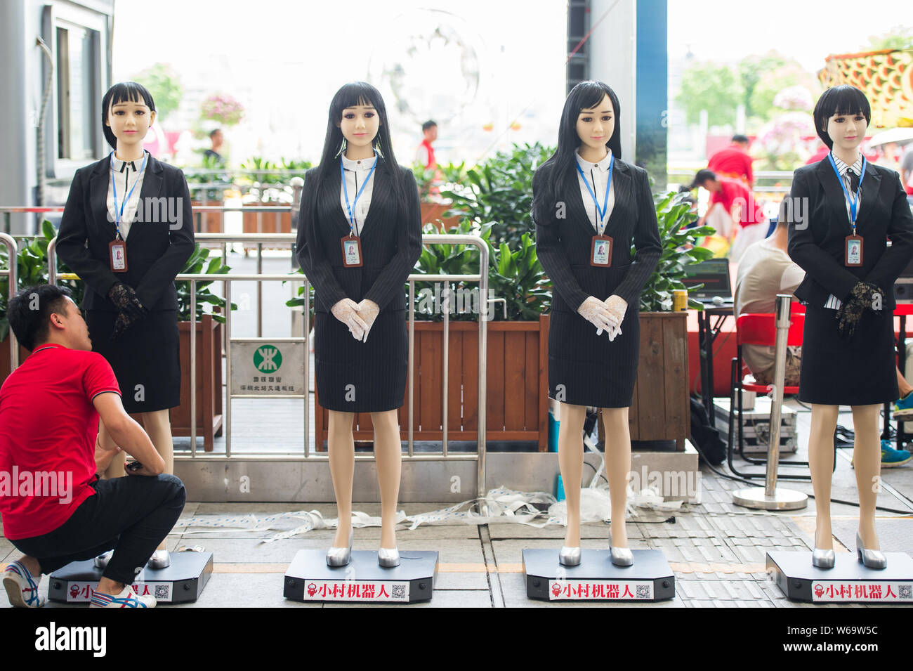 A Chinese worker displays humanoid robots used to raise public ...
