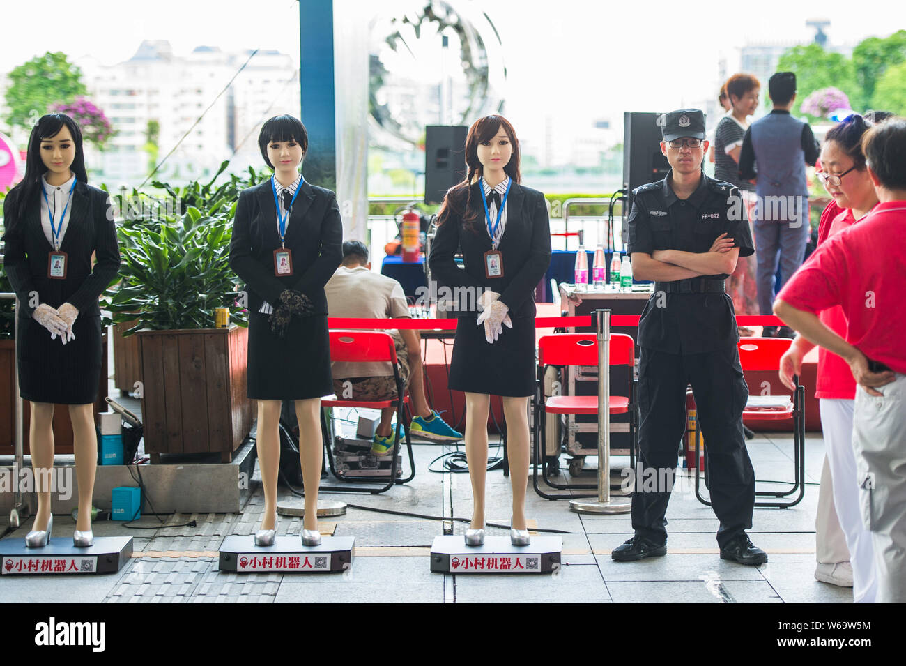 Chinese workers display humanoid robots used to raise public awareness ...