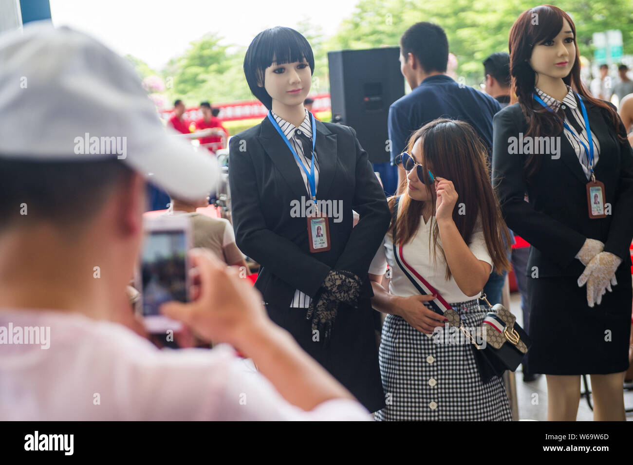 A passenger takes photos of humanoid robots used to raise public ...