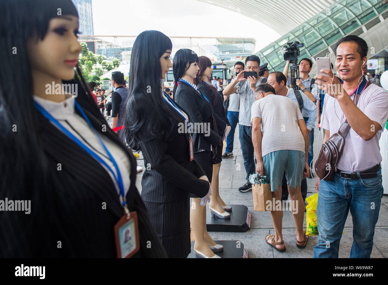 A passenger takes photos of humanoid robots used to raise public ...
