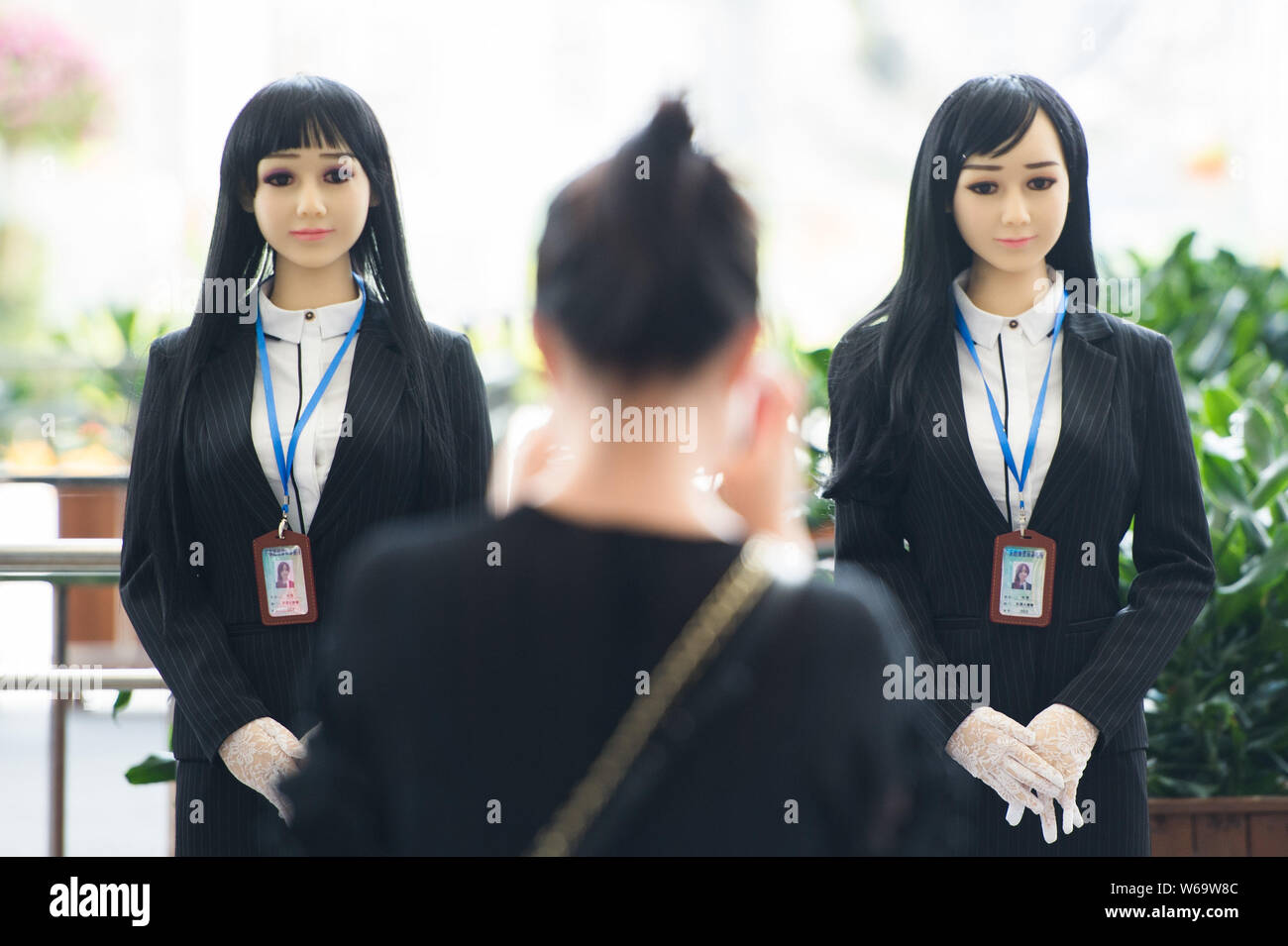 A passenger takes photos of humanoid robots used to raise public ...