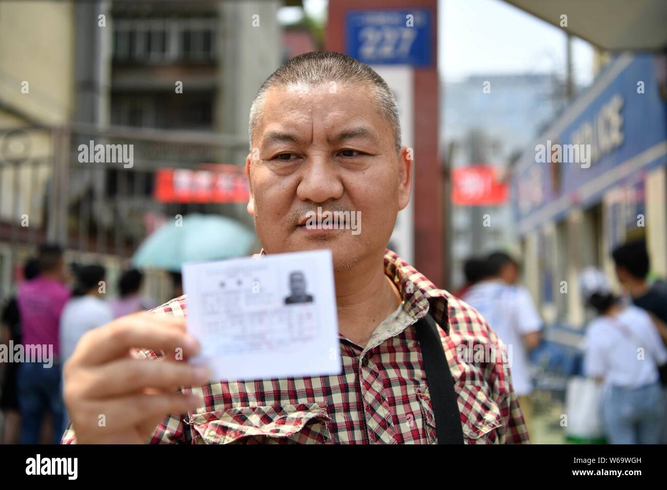 51-year-old Chinese man Liang Shi shows his exam admission ticket after ...
