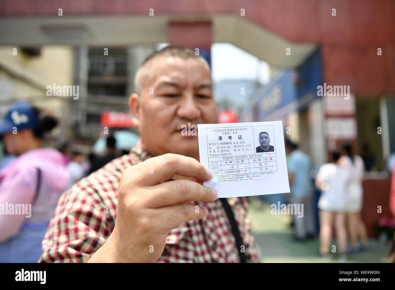 51-year-old Chinese man Liang Shi shows his exam admission ticket after ...