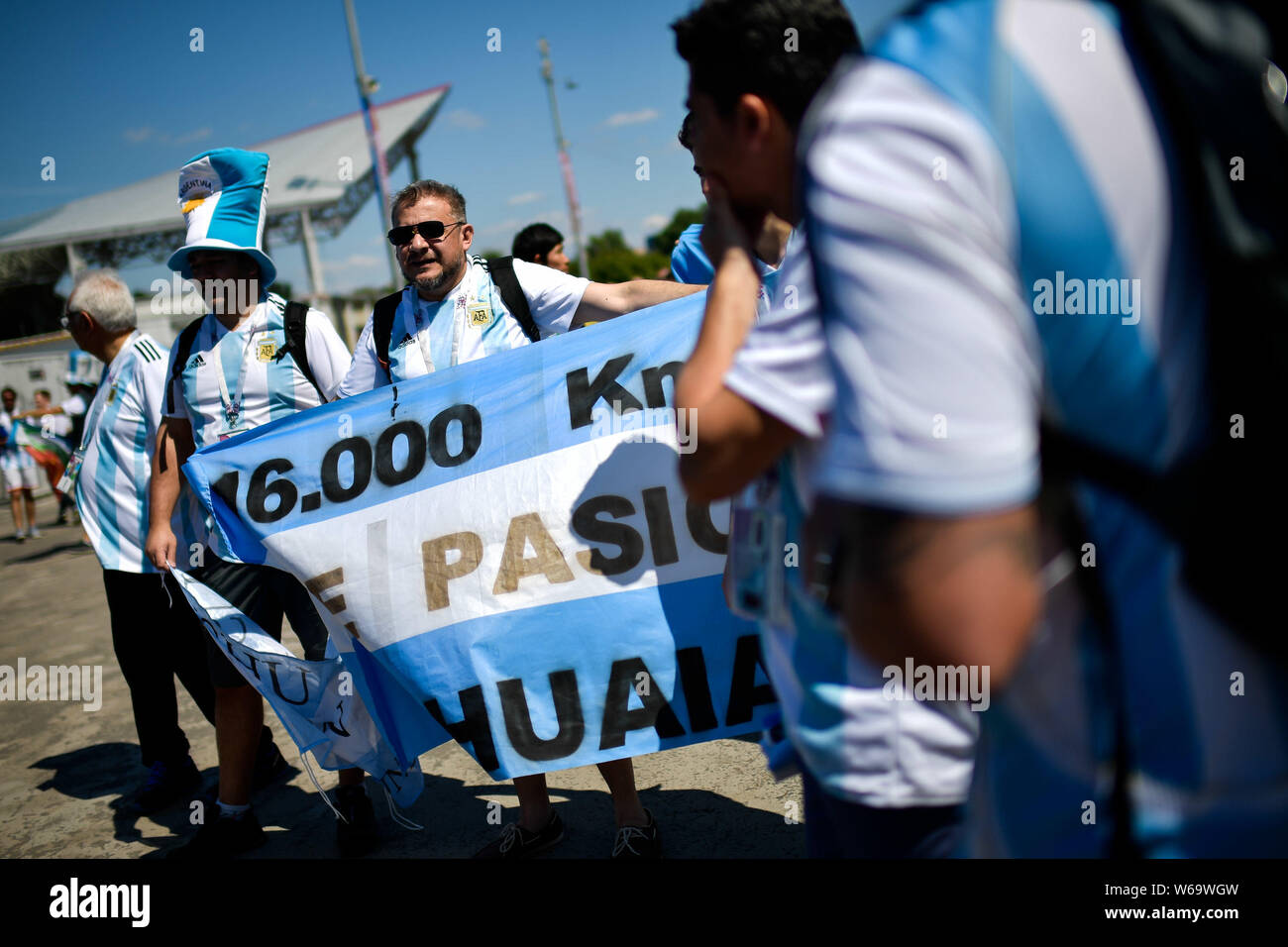 Argentine fans shout and wave their national flags to show their ...