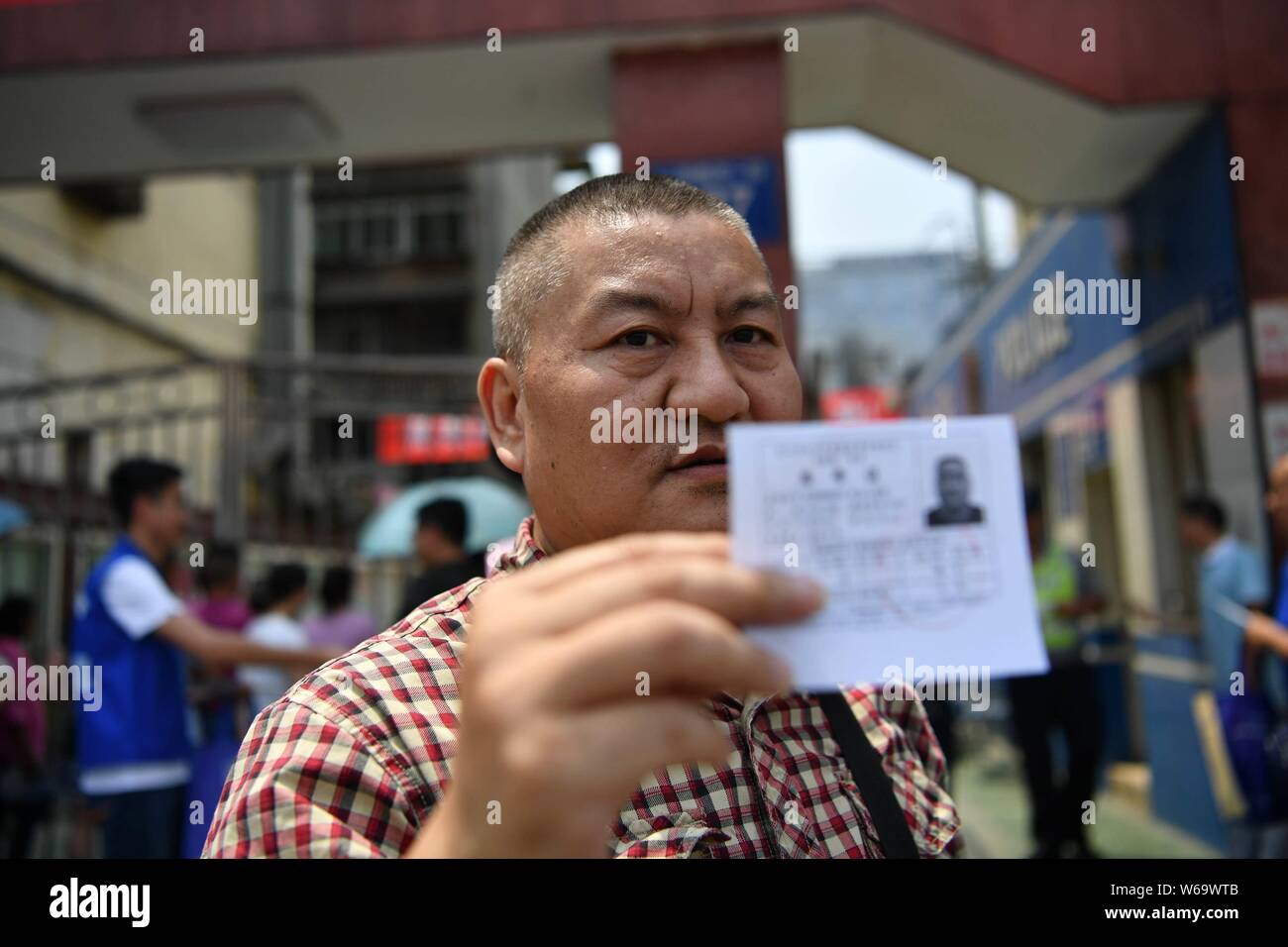 51-year-old Chinese man Liang Shi shows his exam admission ticket after ...