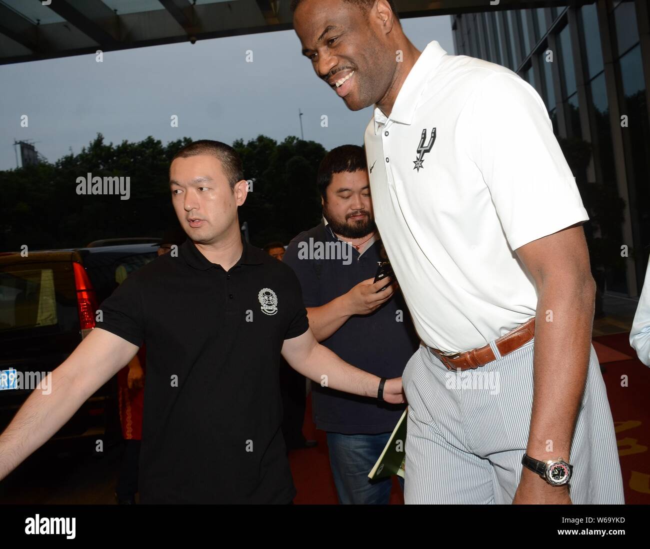 Former NBA star David Robinson, right, poses for photos with a fan as ...