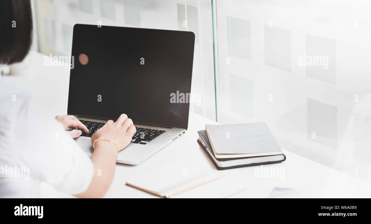 Young female startup member working on her project with laptop computer ...