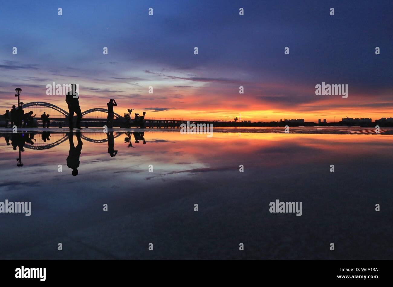 Pedestrians and visitors walk along the Songhuajiang River or Songhua ...