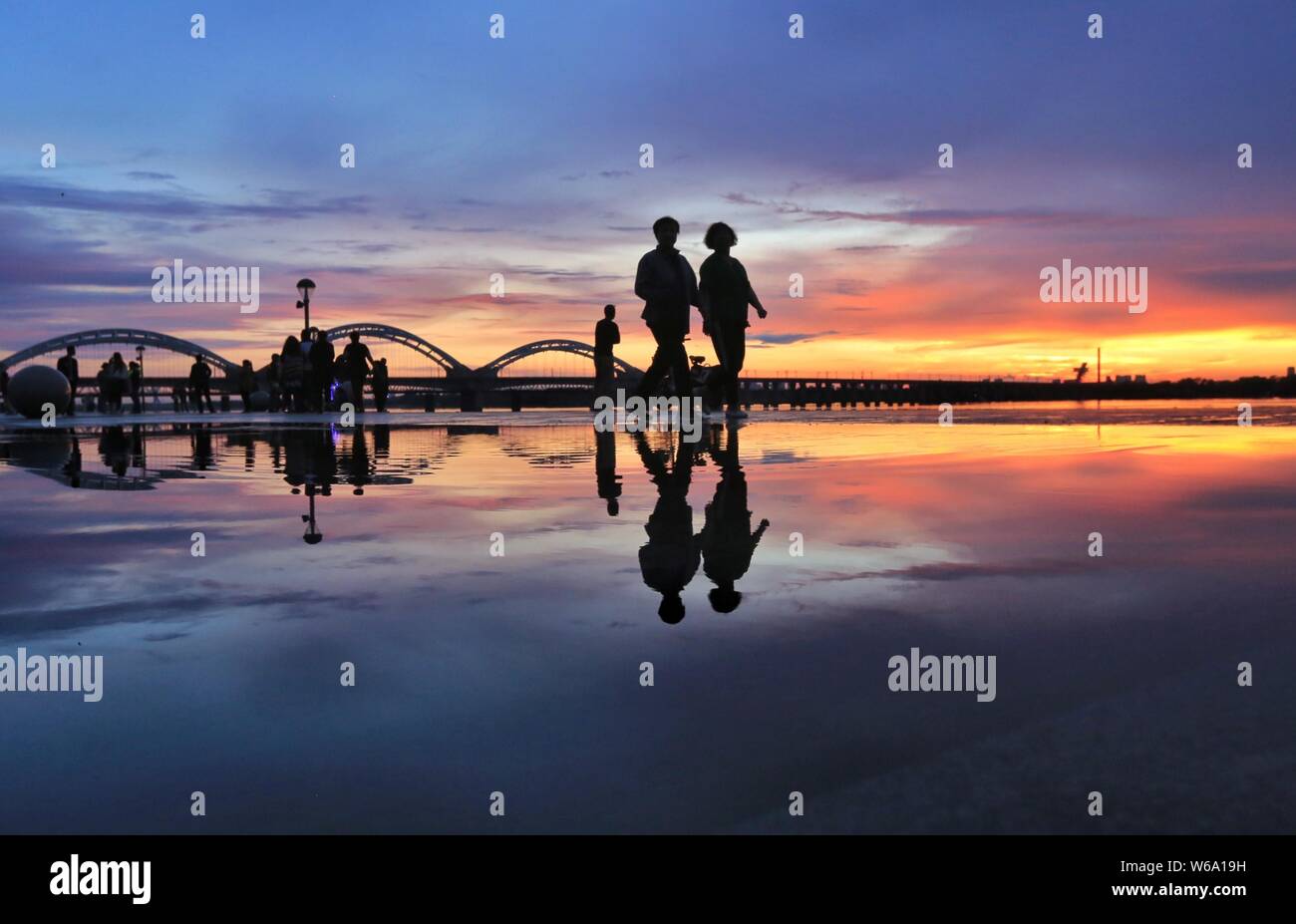 Pedestrians and visitors walk along the Songhuajiang River or Songhua ...
