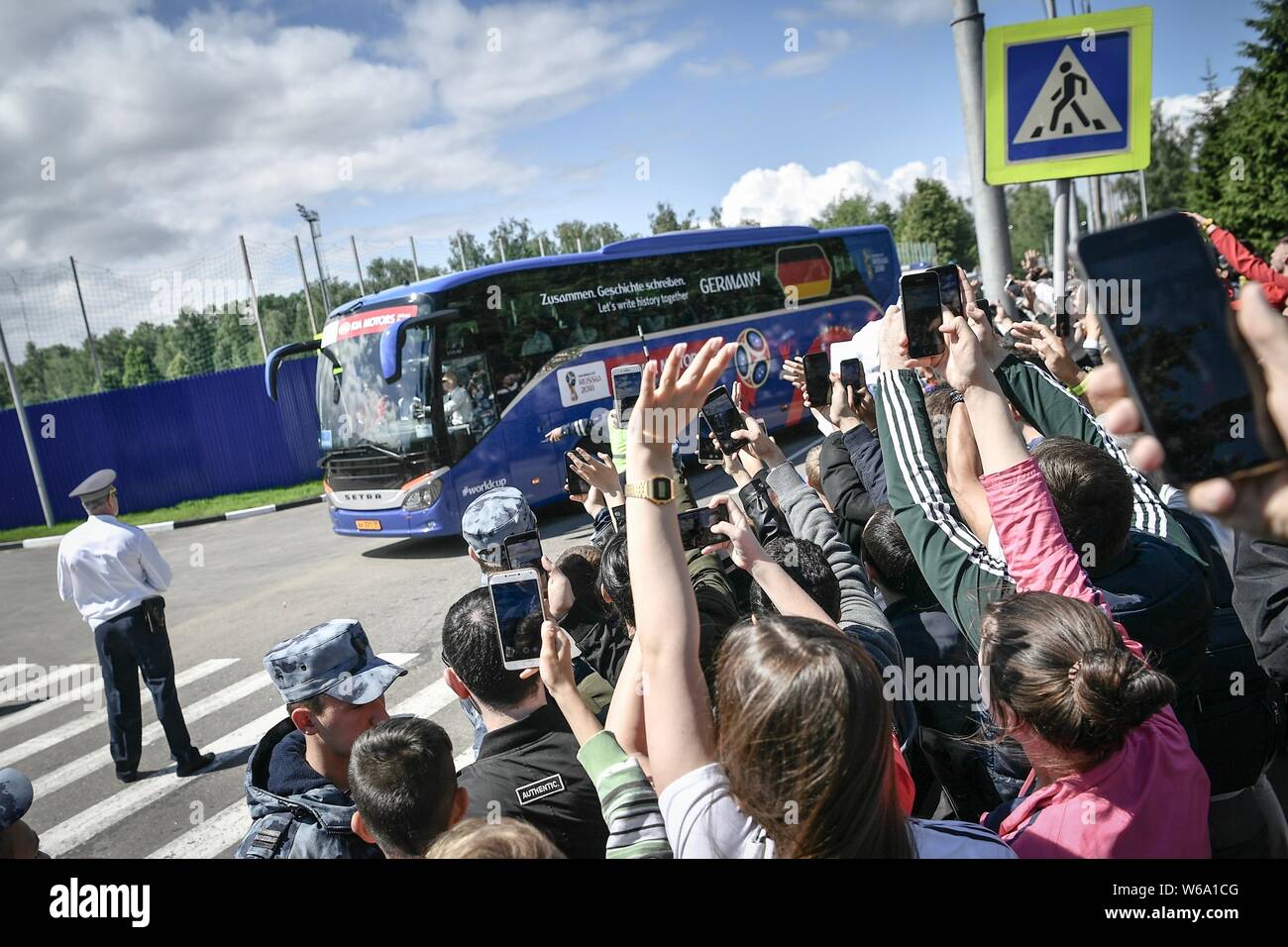 Crowds of football fans take photos of the bus carrying German players ...