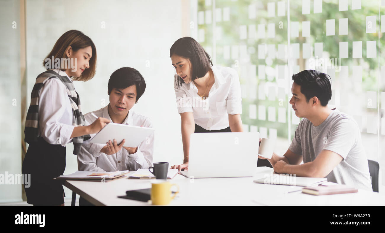 A group of young startup team brainstorming their plan for the upcoming ...