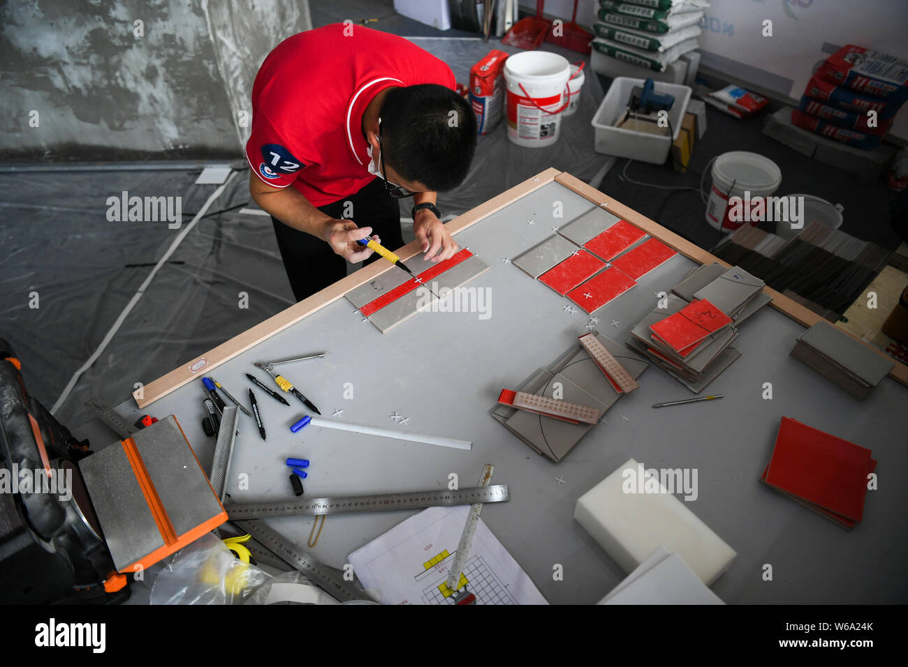 A participant shows wall tiling skill as he attends the WorldSkills ...