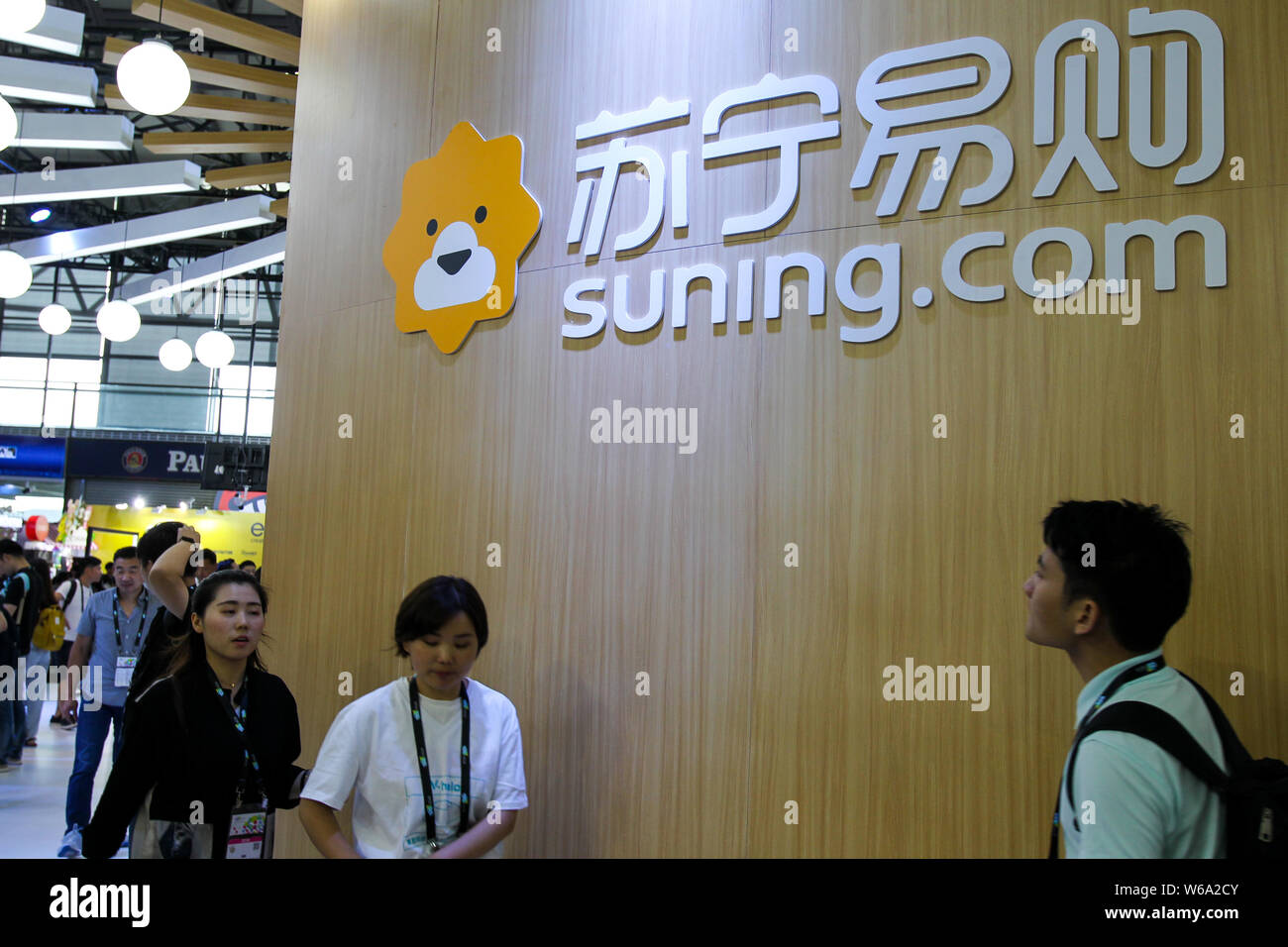 --FILE--Visitors walk past the stand of Suning.com, the online shopping ...