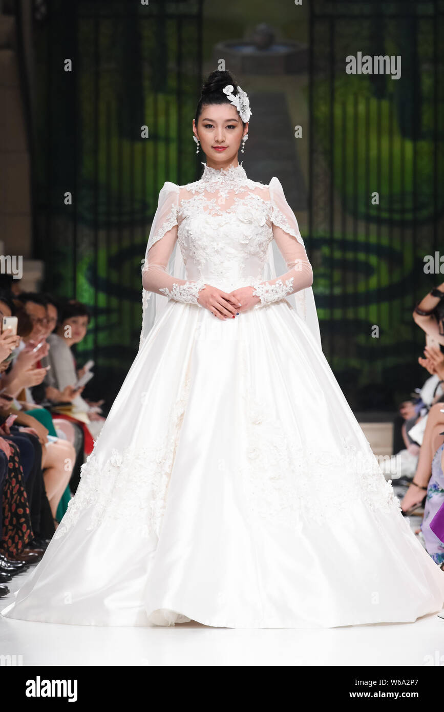 A model displays a new creation at the fashion show of Yumi Katsura ...