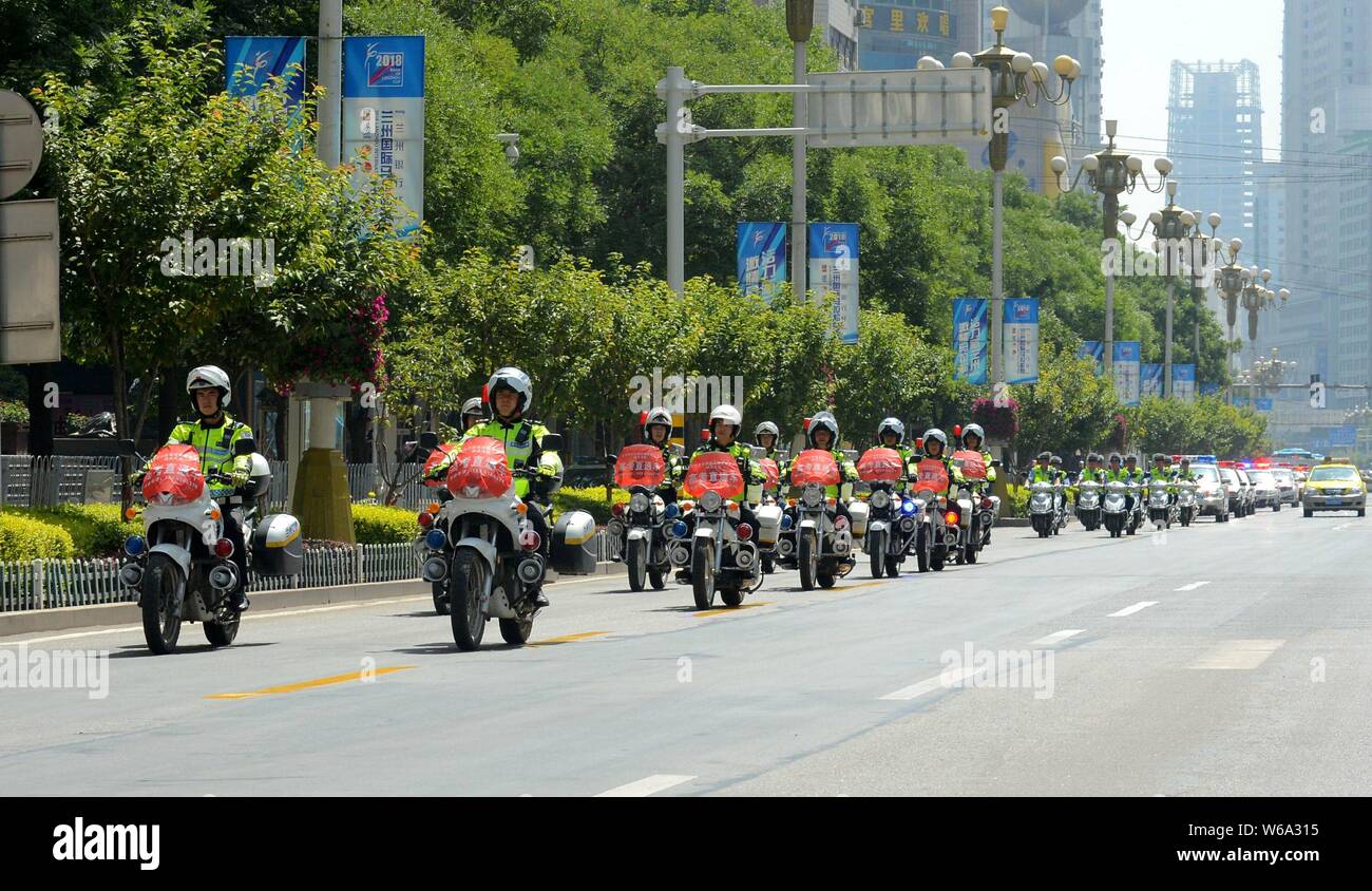 Chinese auxiliary traffic police officers ride motorcycles during a ...
