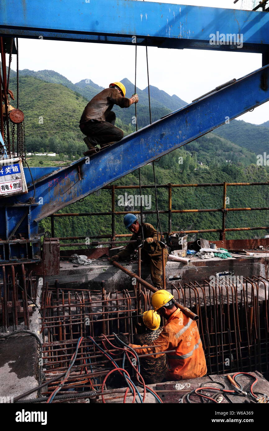 Chinese workers labor at the construction site of the stayed cable ...