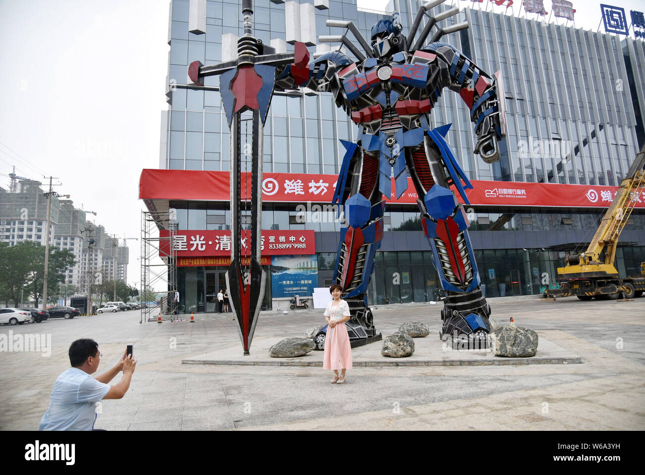 Local Chinese residents take pictures before a replica of Optimus Prime ...