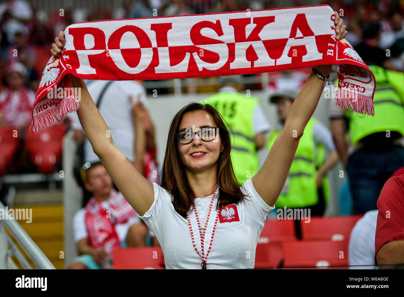 A hot female Polish fan wearing a red and white jersey watches the ...