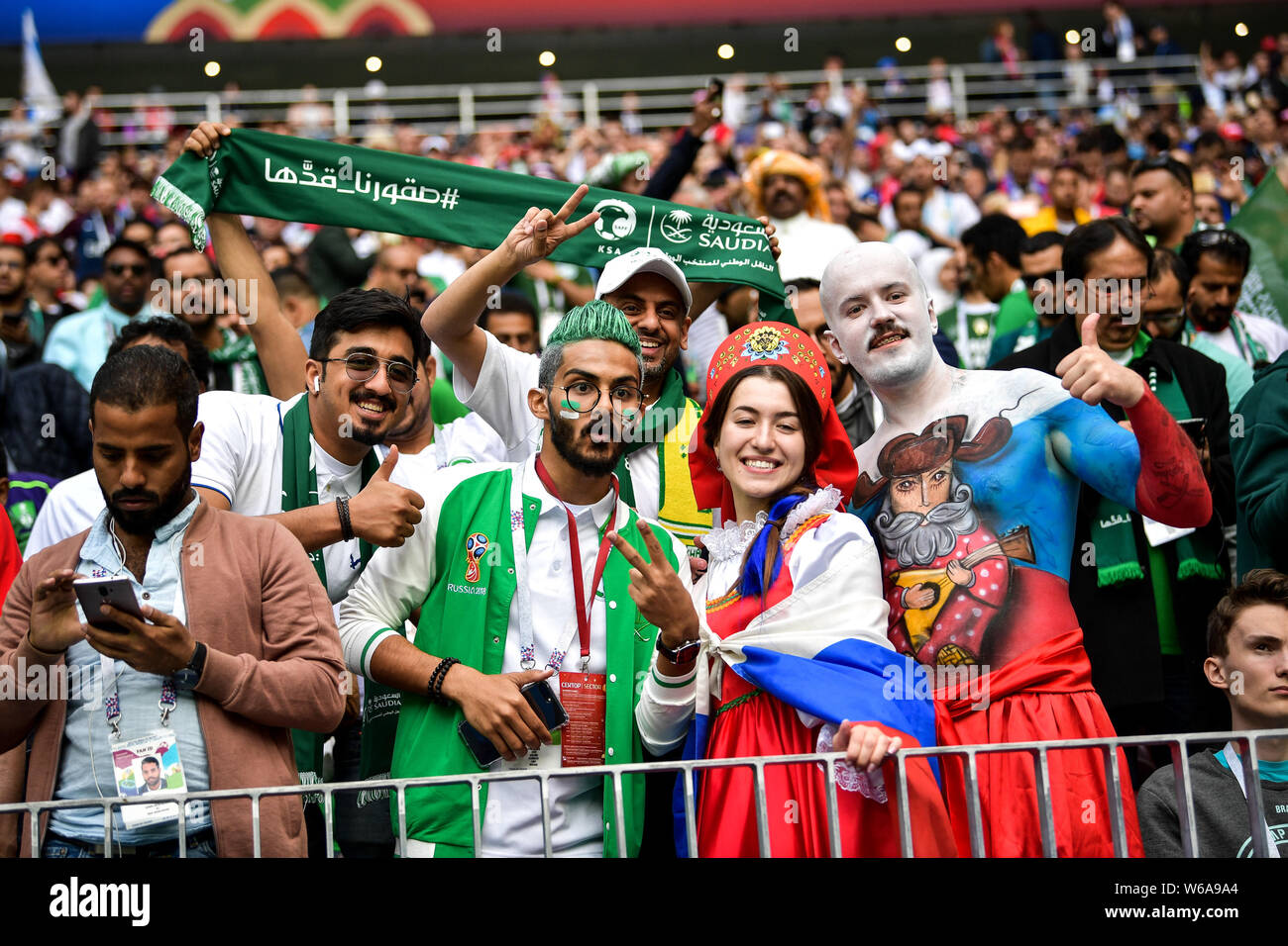 Russian and Saudi Arabian football fans pose during the opening ...