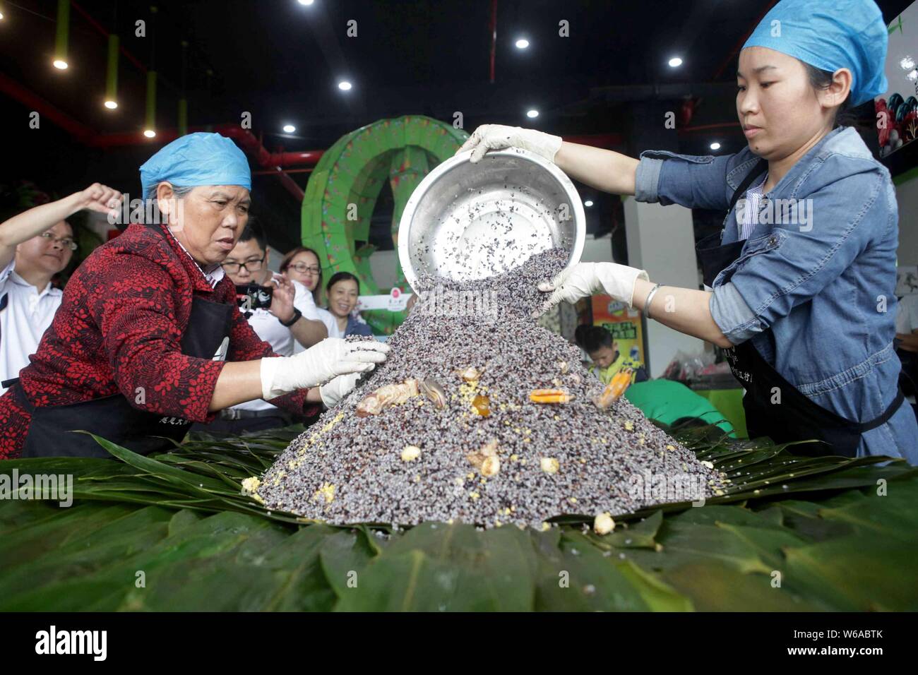 Chinese workers make a huge zongzi, a pyramid-shaped dumpling made of ...